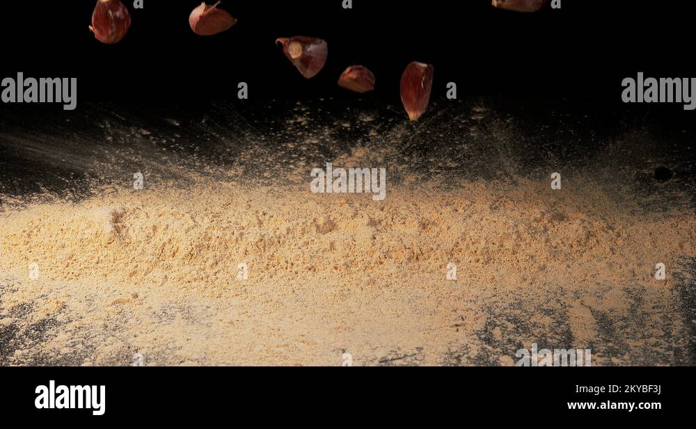 Garlic, allium savitum, Garlic pawns Falling on Garlic Powder on Black ...