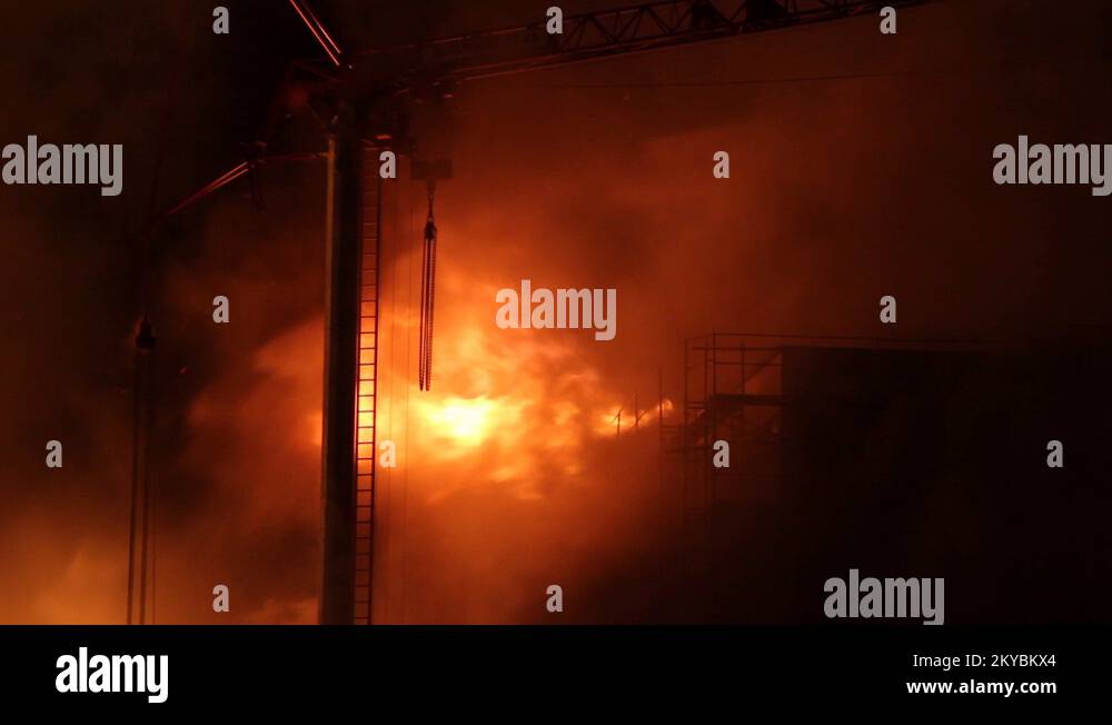 Heavy flames shooting out of the top of building under construction ...