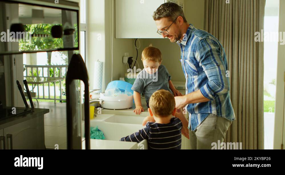 Father and siblings cleaning kitchen sink 4k Stock Video Footage - Alamy