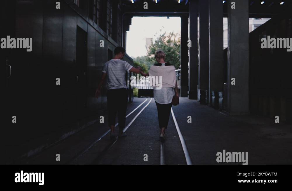 Slow motion back view happy romantic couple walking together holding ...