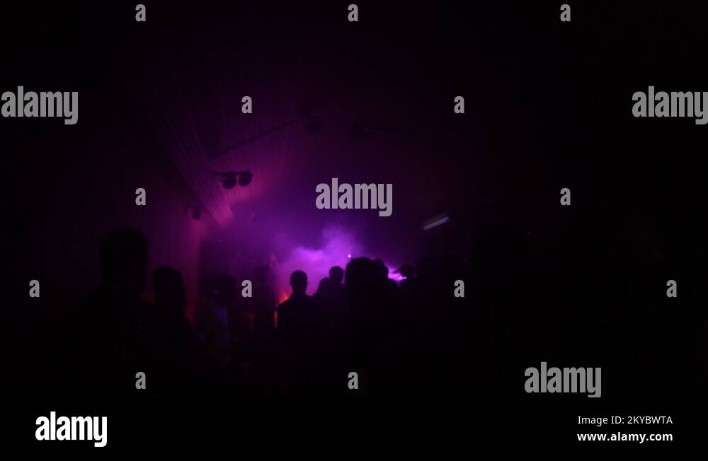 Lively underground rave with flashing lights, fog, and dancing crowd ...