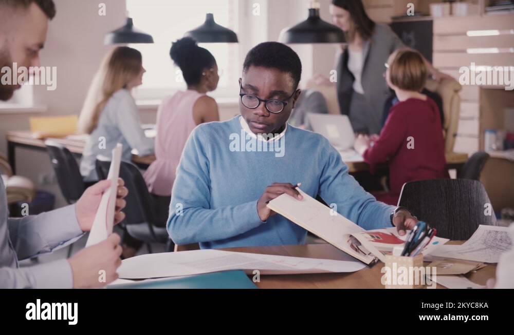 Two concentrated managers work through different papers and diagrams ...