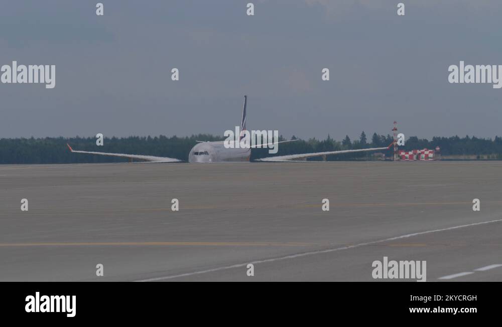 Big jet airliner slowly moves on runway. Wide spread wings flicker in ...