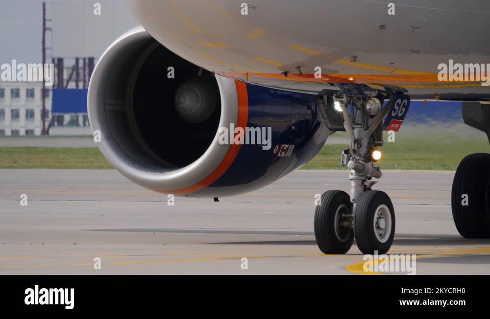 Landing gear and engine of jet airliner. Fuselage reflects taxiway ...