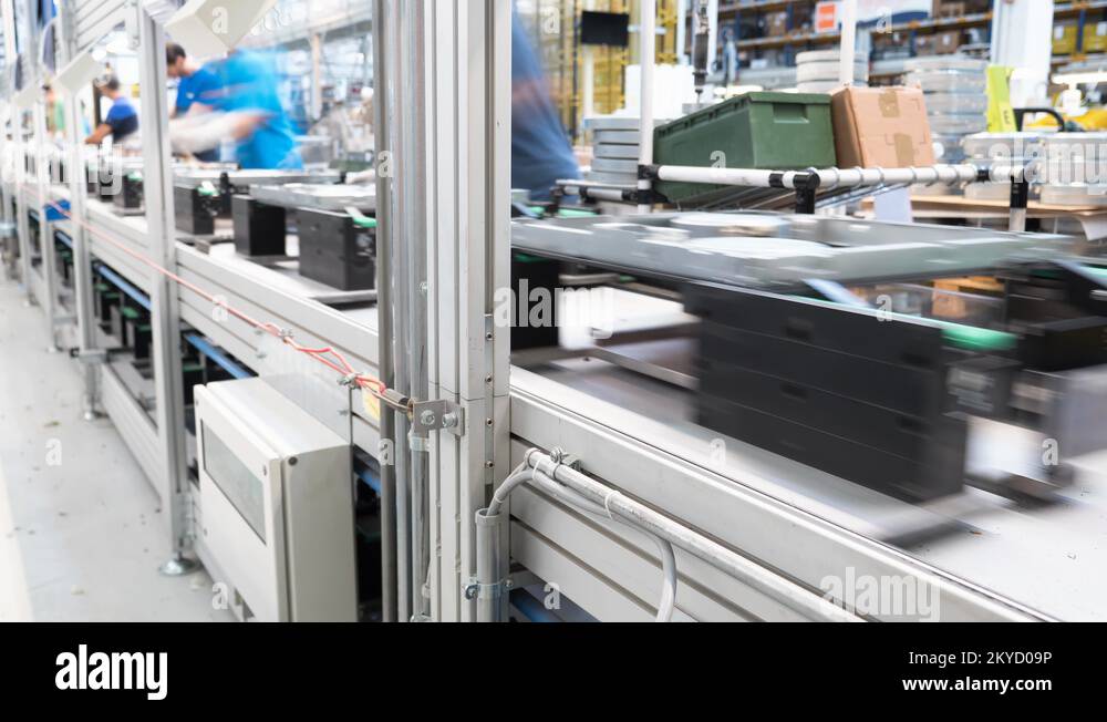 Time-lapse group of workers manually assemble components on a assembly ...