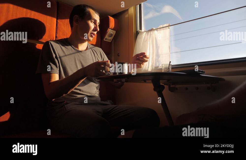 man is sitting in a Railway carriage train at the window of a ...