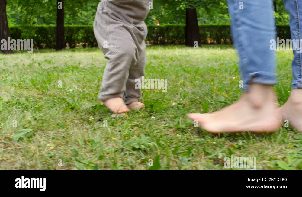 Barefoot Mother Teaching Baby to Walk in Park Stock Video Footage - Alamy