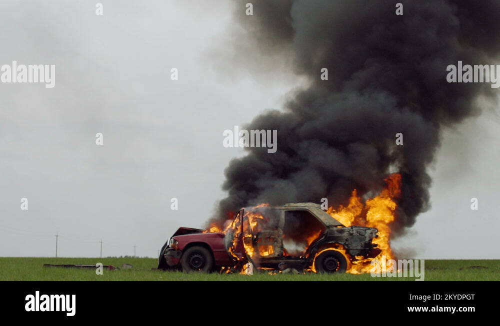 A sad man at a burning car, sadness and sadness, a fire, a guy expects ...