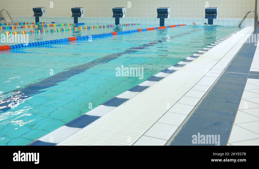 A professional swimmer swims the backstroke in an indoor pool Stock ...