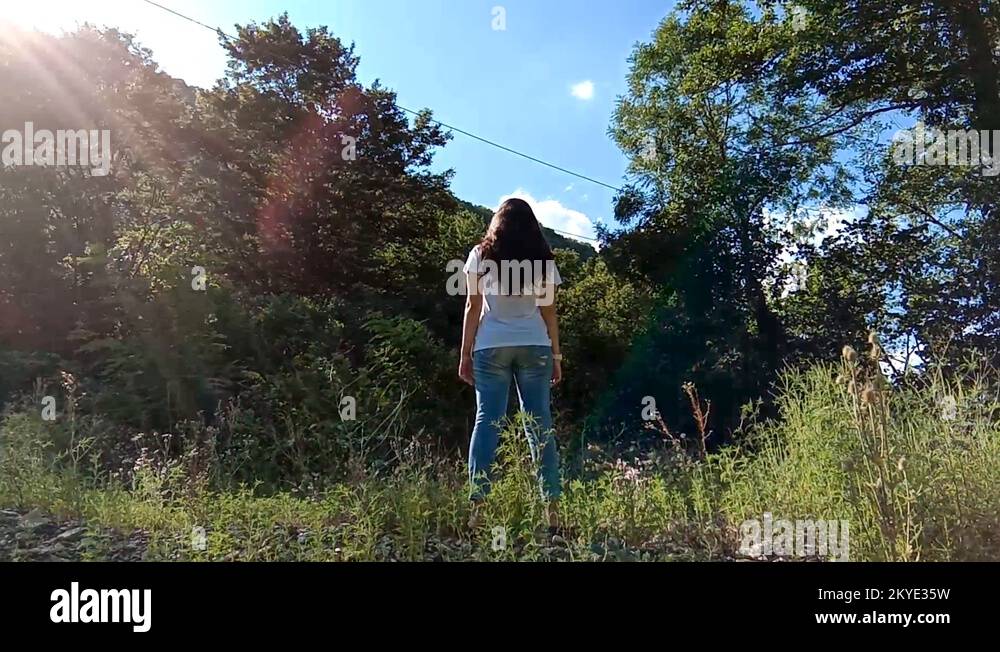 Back view of Teenage Girl at the Summer Field with sun reflection ...