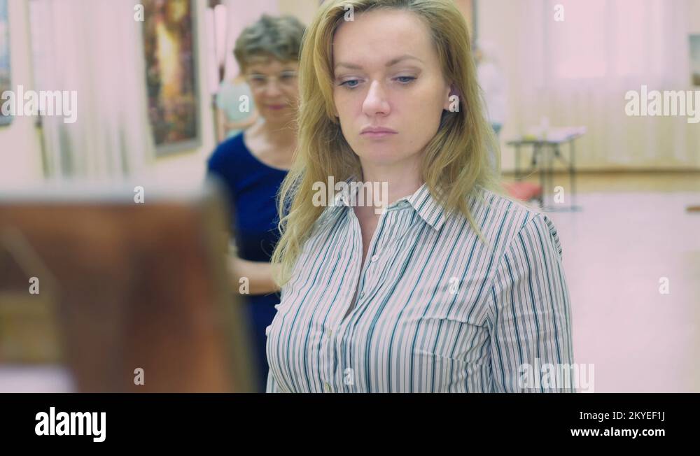 beautiful woman looks at the pictures in the picture gallery. art ...