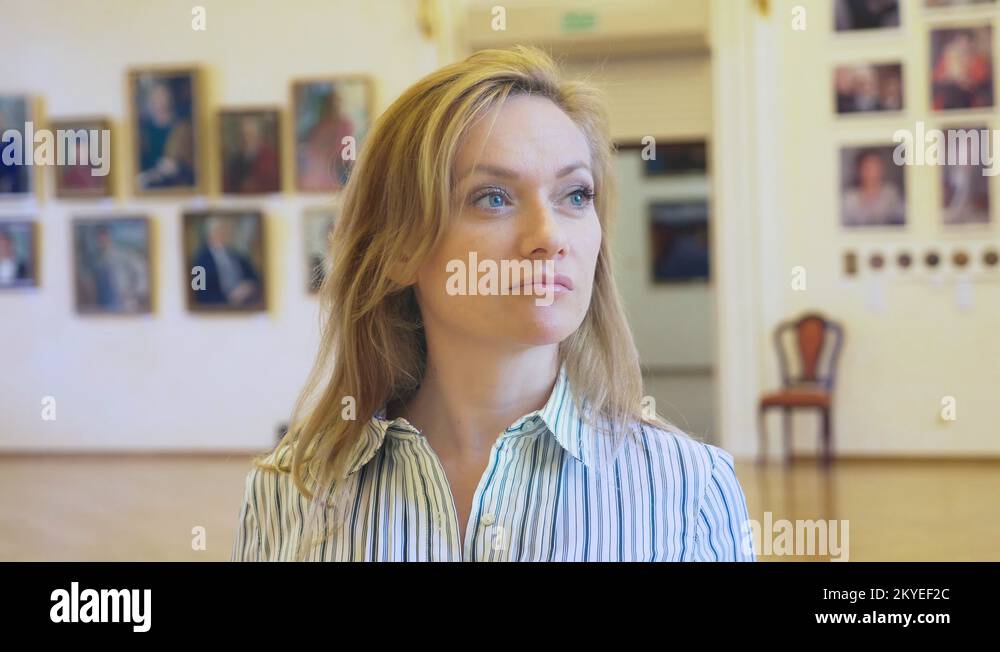 beautiful woman looks at the pictures in the picture gallery. art ...