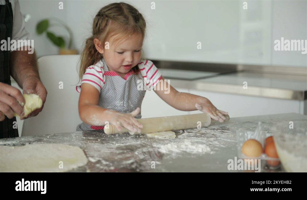 Daughter Helping Father To Cook Meal In Kitchen. Dad Teachs Her Kid How ...