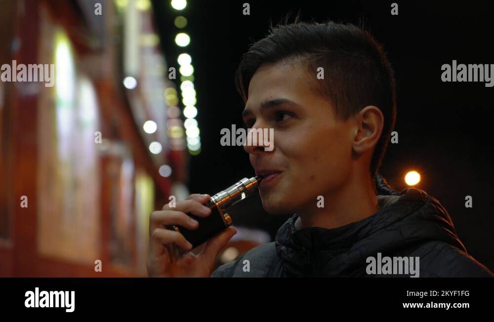young cute man vaping near entertainment centre at night, 4k 2 Stock ...