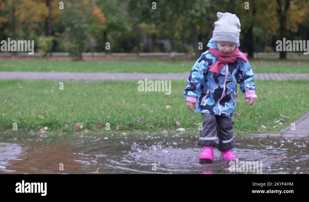 Cute baby jumping on a puddle Stock Video Footage - Alamy