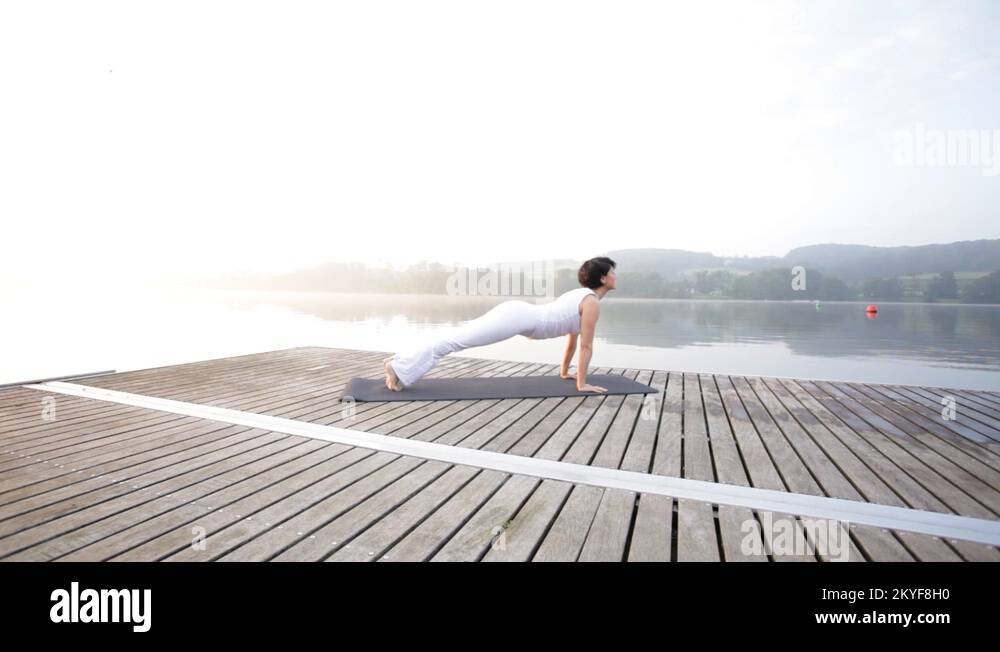Lockdown shot of mature woman practicing downward facing dog position ...