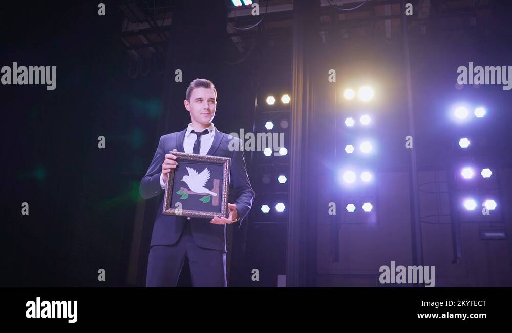 Magic man show trick with white dove at red curtain background in ...