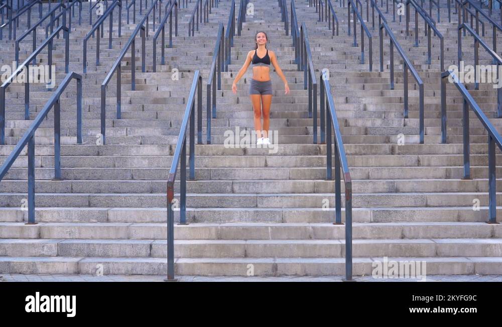 Peaceful healthy young girl doing tree pose on right foot on stairs in ...