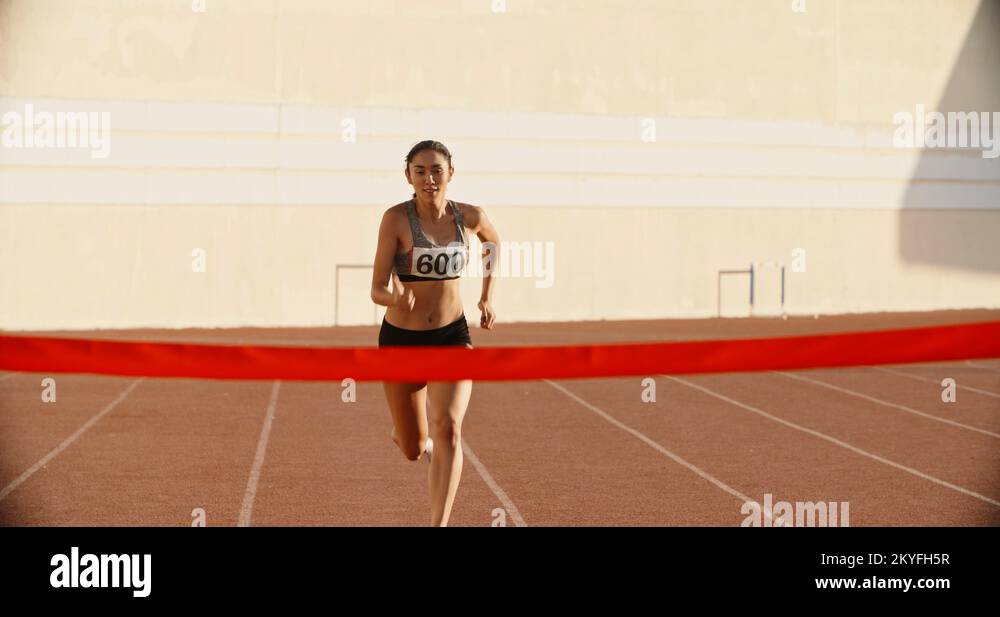Female athlete on track. Young asian runner runing on track of stadium ...