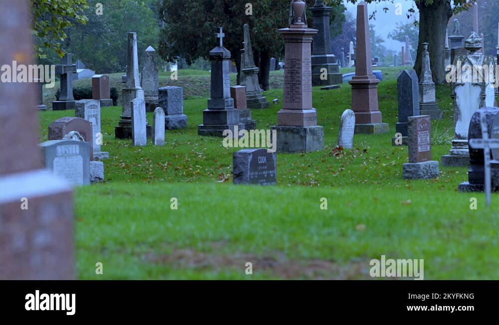 Grave stones, headstones, and monuments at a cemetery. Eerie background ...