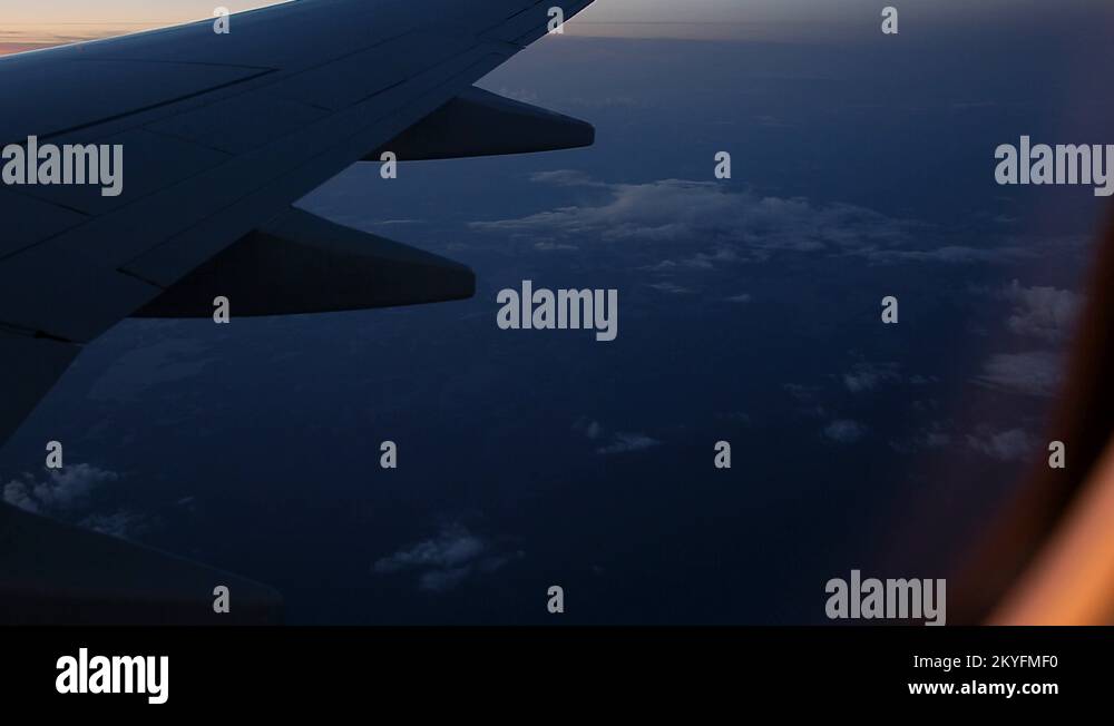 A view out of an aircraft window looking over the wing at sunset Stock ...