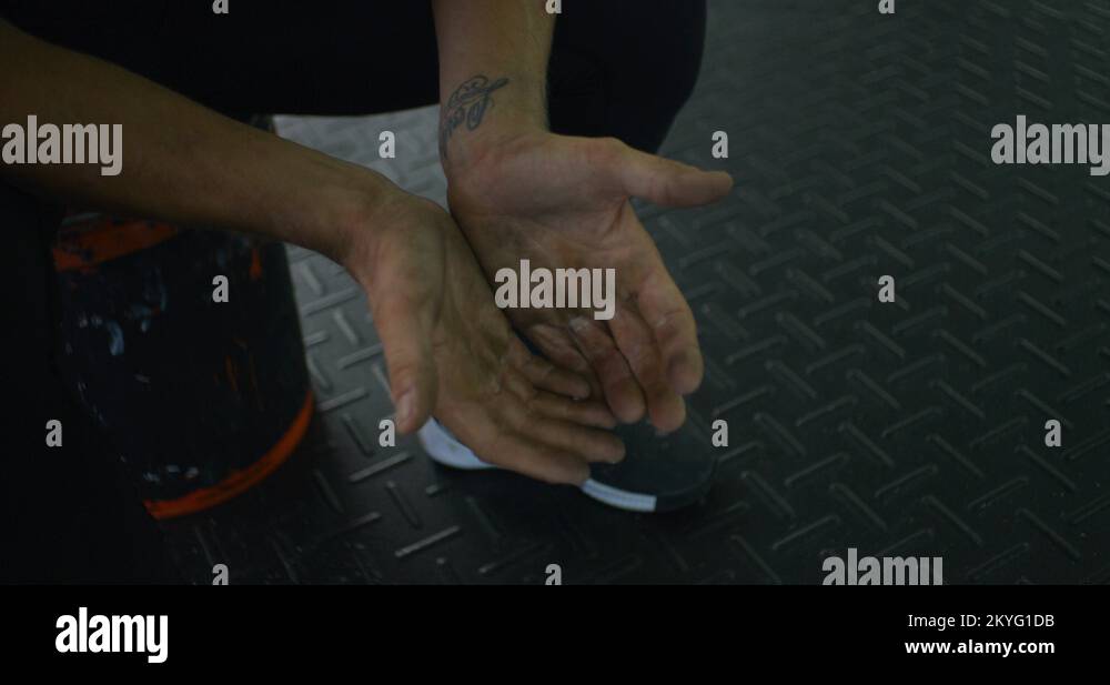 Athlete looking at their rough hands after a workout in a crossfit gym ...