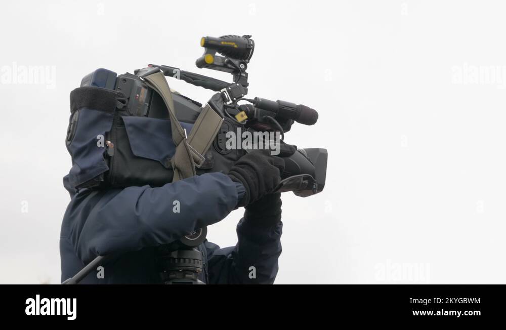 Videographer with a movie camera close-up isolated on white. Making a ...