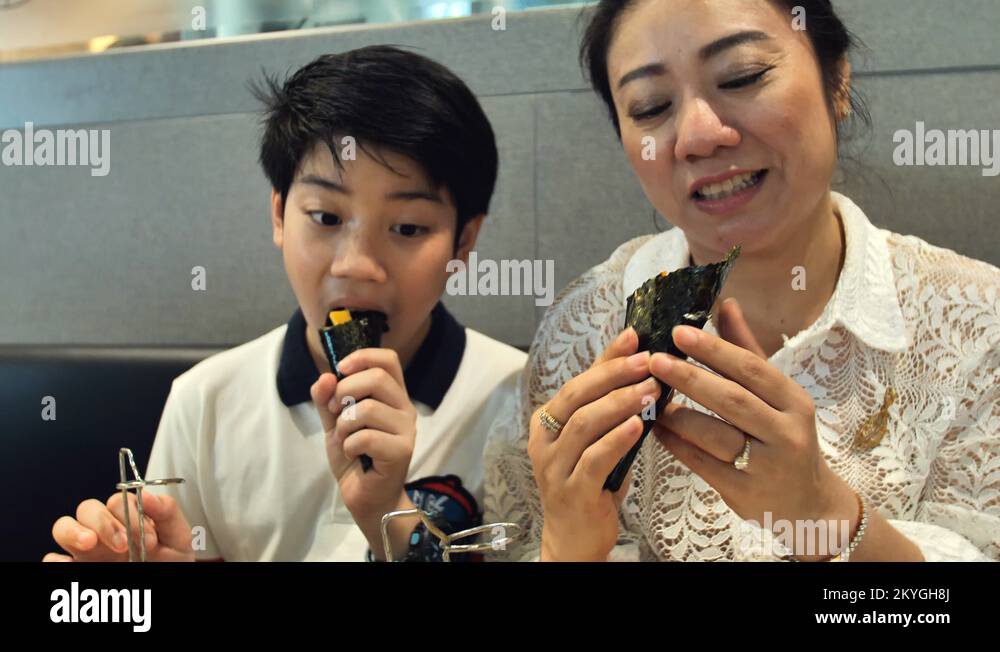 Slow motion of Happy asian family ,Mother and son eating japanese food ...