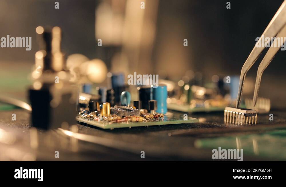 Assembling a circuit board. Putting microcircuit on PCB with tweezers ...