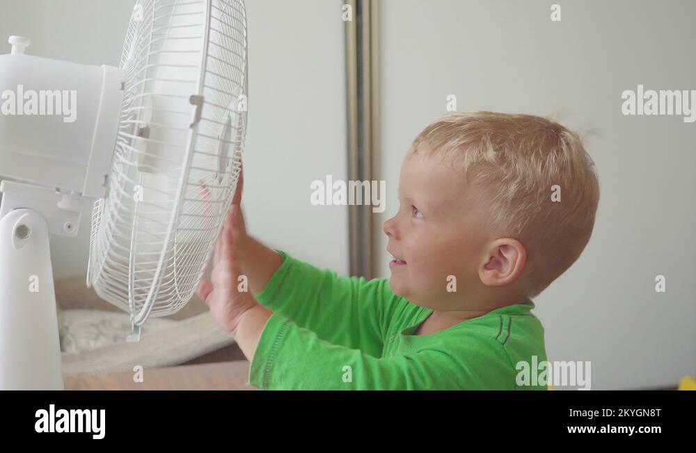 childhood, home concept - cute little boy with big cooling fan Stock ...