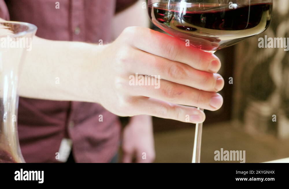 Barman at work. Male hand stirring a wine glass with red wine in it. 4K ...