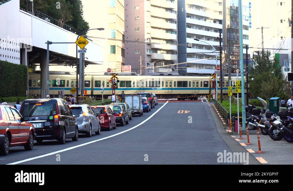 Tokyo, Japan - Train Crossing At Level crossing While Cars Wait Behind ...
