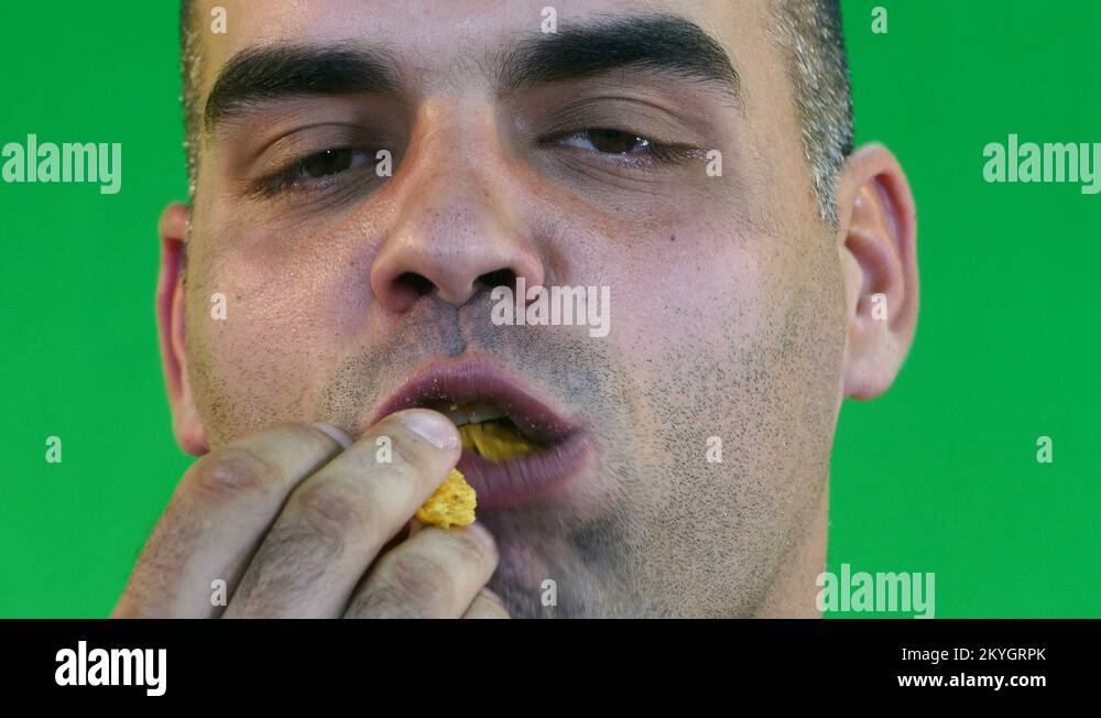 Man Eating Tortilla Chips In Closeup - Green Background 4k Stock Video ...