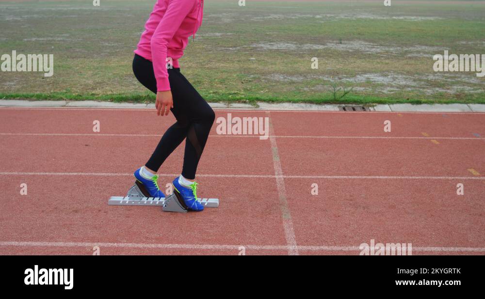 Female athlete taking starting position on running track 4k Stock Video ...