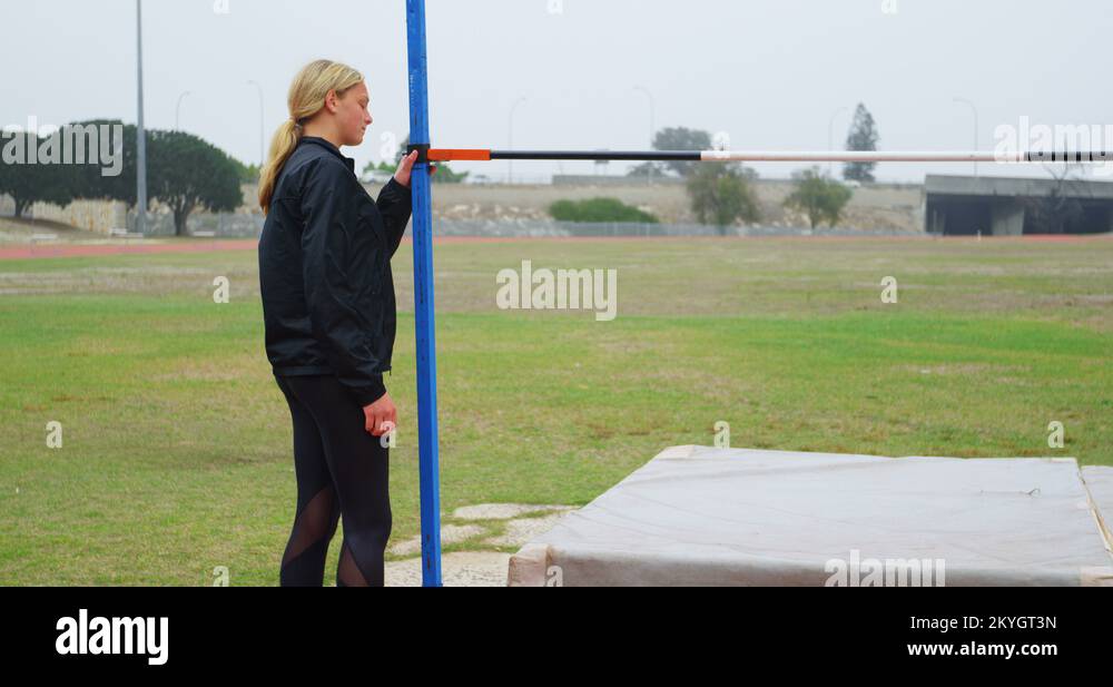Female athlete checking high jump bar at sports venue 4k Stock Video ...