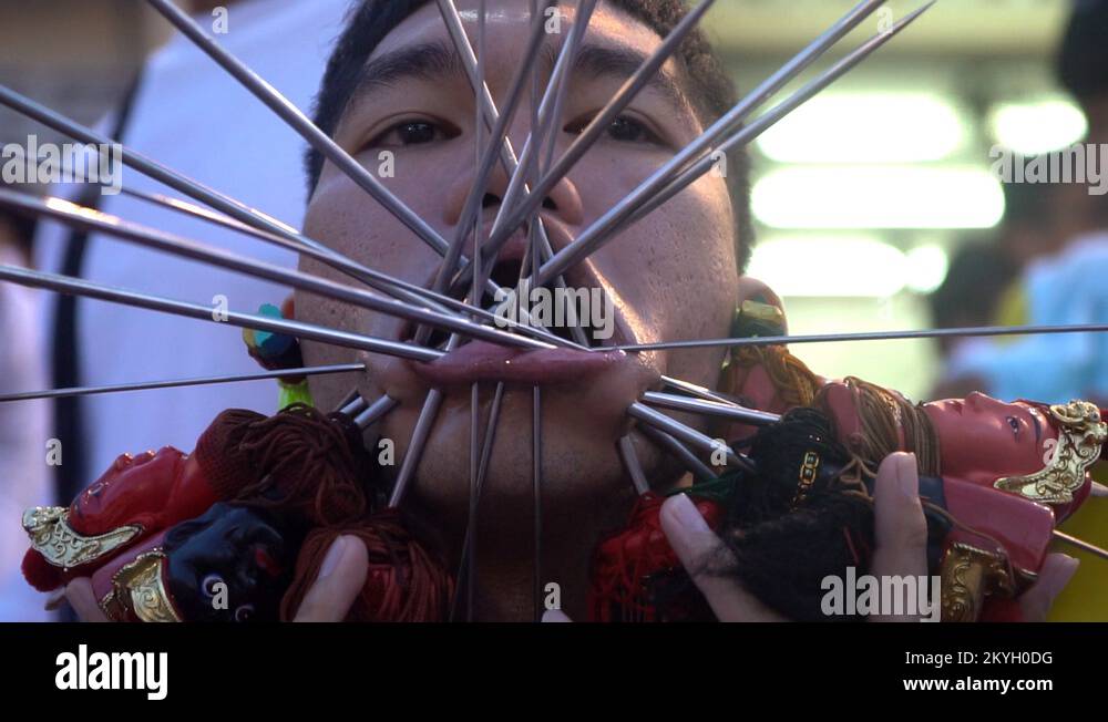 A follower of the Chinese Shrine, pierces cheeks with skewers Stock ...