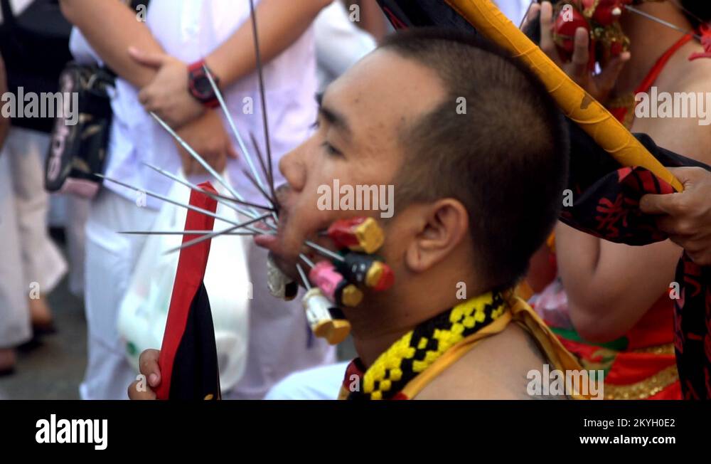 A follower of the Chinese Shrine, pierces cheeks with skewers Stock ...