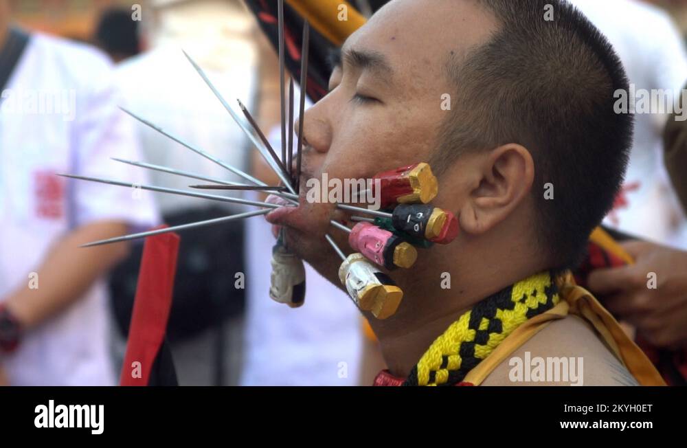 A follower of the Chinese Shrine, pierces cheeks with skewers Stock ...