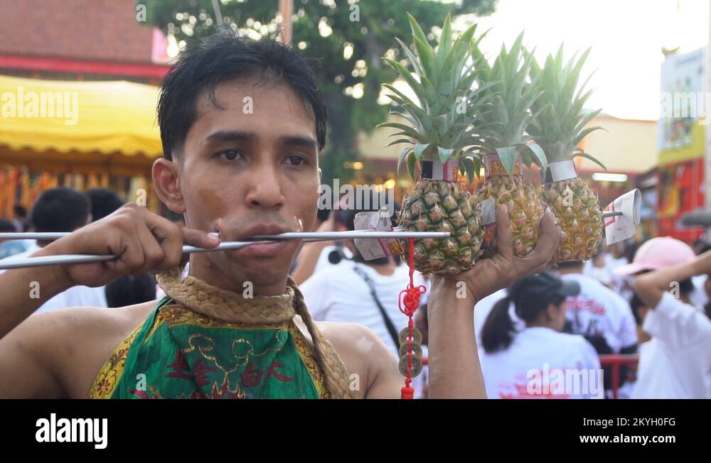 A follower of the Chinese Shrine, pierces cheeks with skewers Stock ...