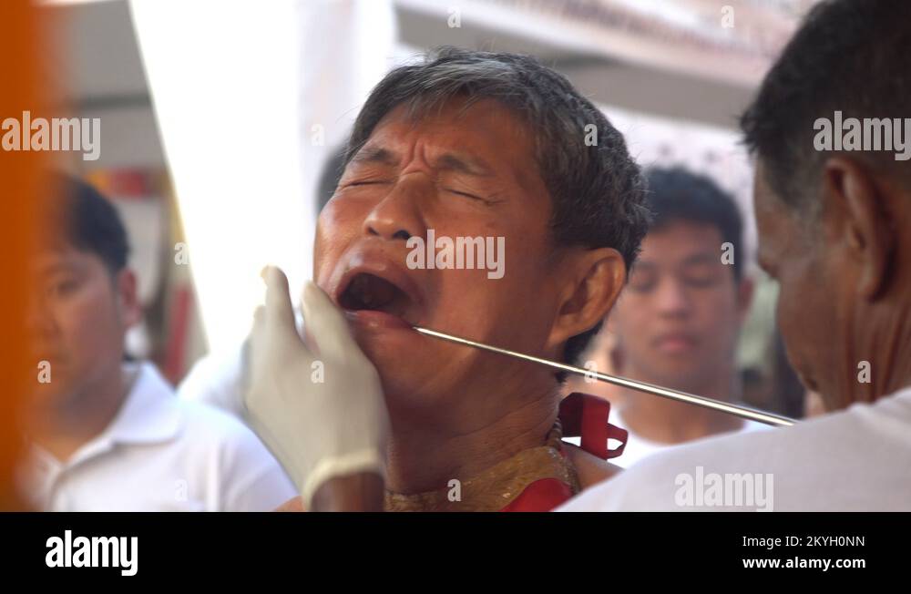 A follower of the Chinese Shrine, pierces cheeks with skewers Stock ...