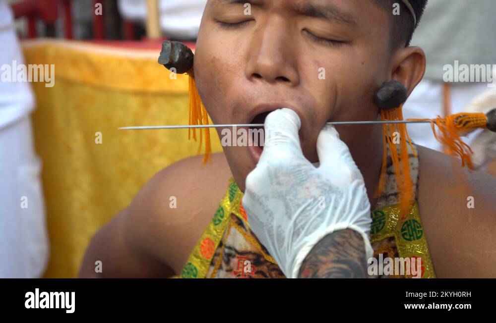 A follower of the Chinese Shrine, pierces cheeks with skewers Stock ...