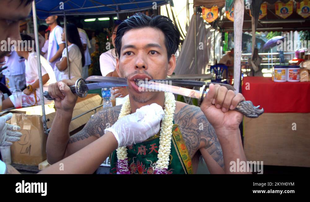 A follower of the Chinese Shrine, pierces cheeks with skewers Stock ...