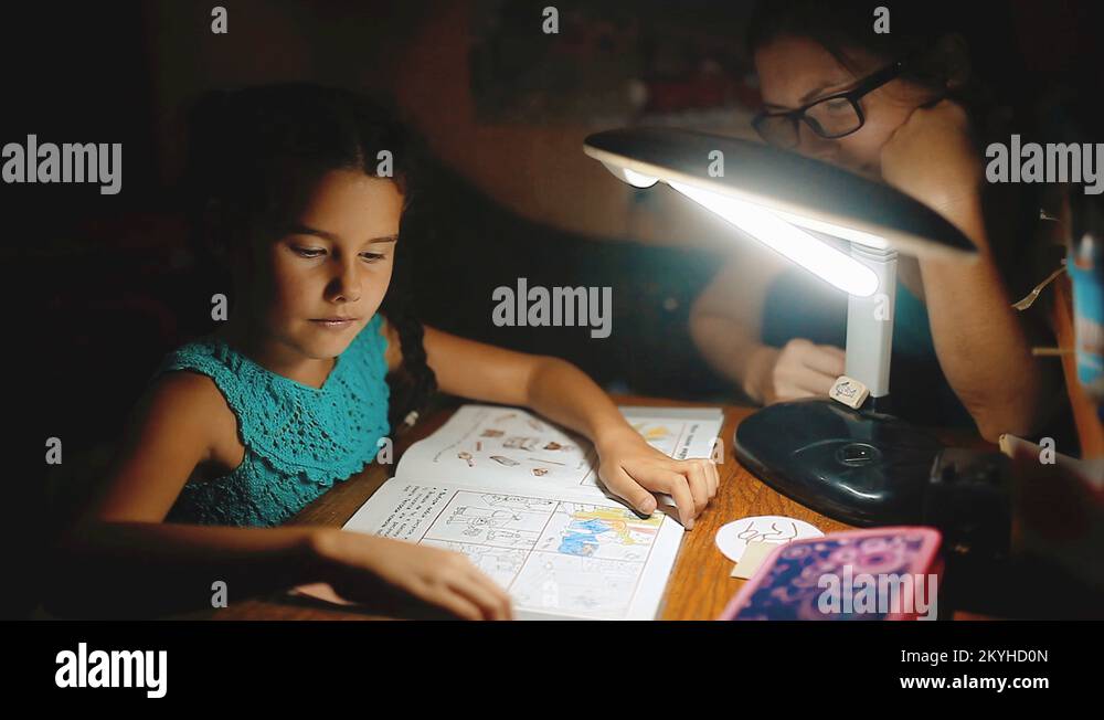 little girl does homework reads a book and writer at night. Evening ...