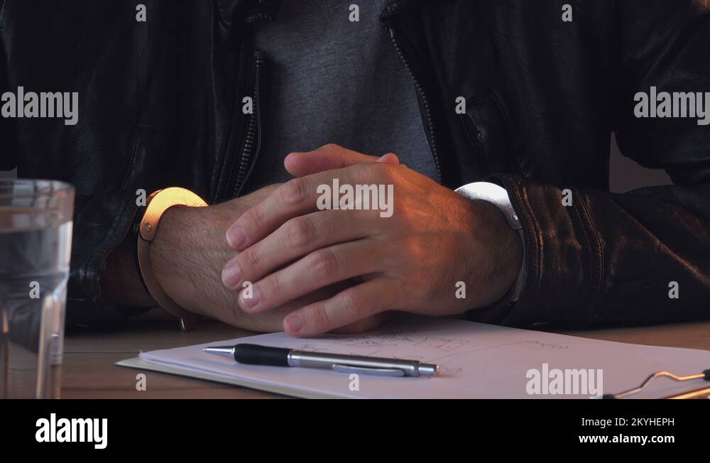 Handcuffed criminal giving statement during police interrogation Stock ...