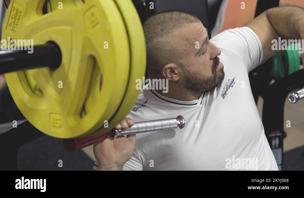 Bodybuilder doing exercise on simulator in gym. Man flexing chest ...