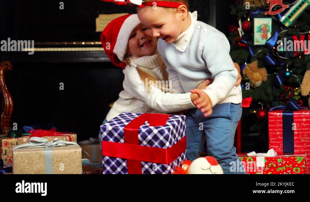 Playful cute girl tickling happy little brother surrounded by beautiful ...