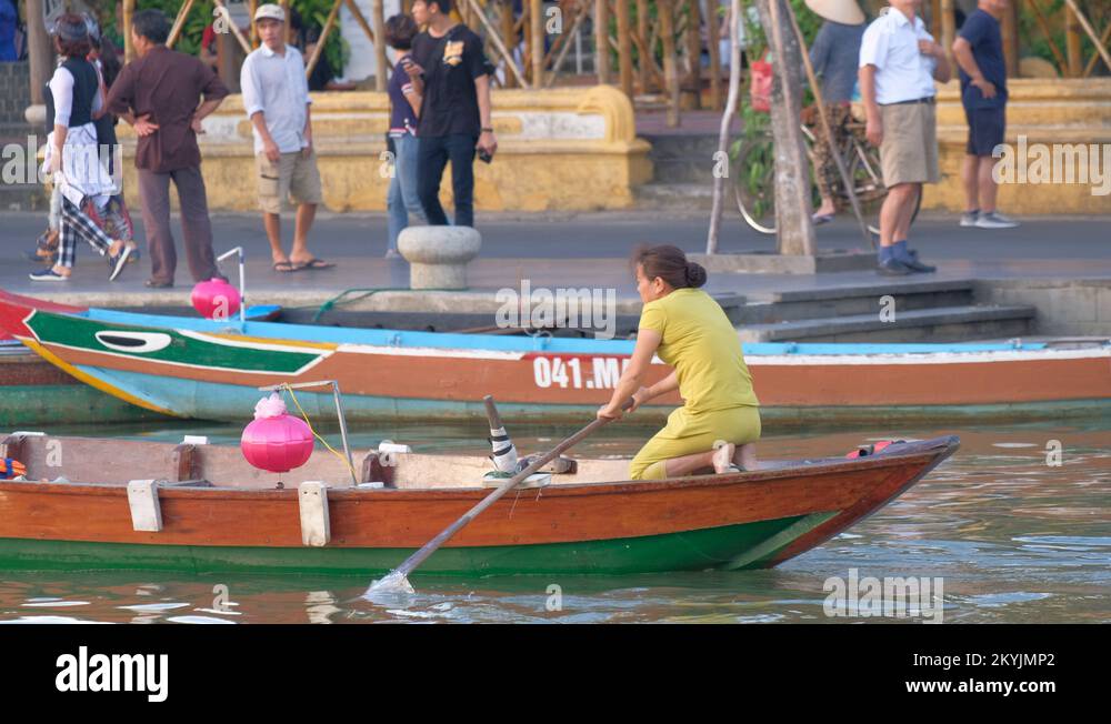 Traditional boatman is rowing wooden boat on river in Hoi An Ancient ...