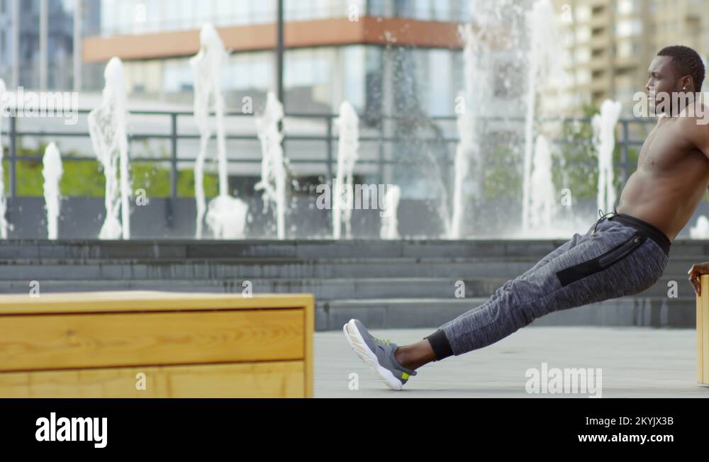 Shirtless African Athlete Doing Bench Dips Outdoors in Downtown Stock ...