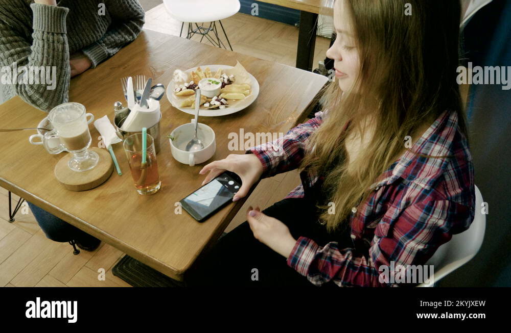 Teenage girl taking a photo with her boyfriend on smartphone in ...