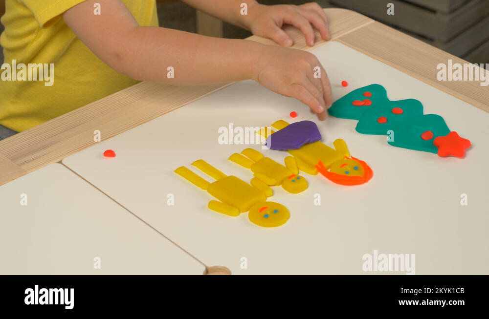 A two years old preschool child making figures from modeling clay ...